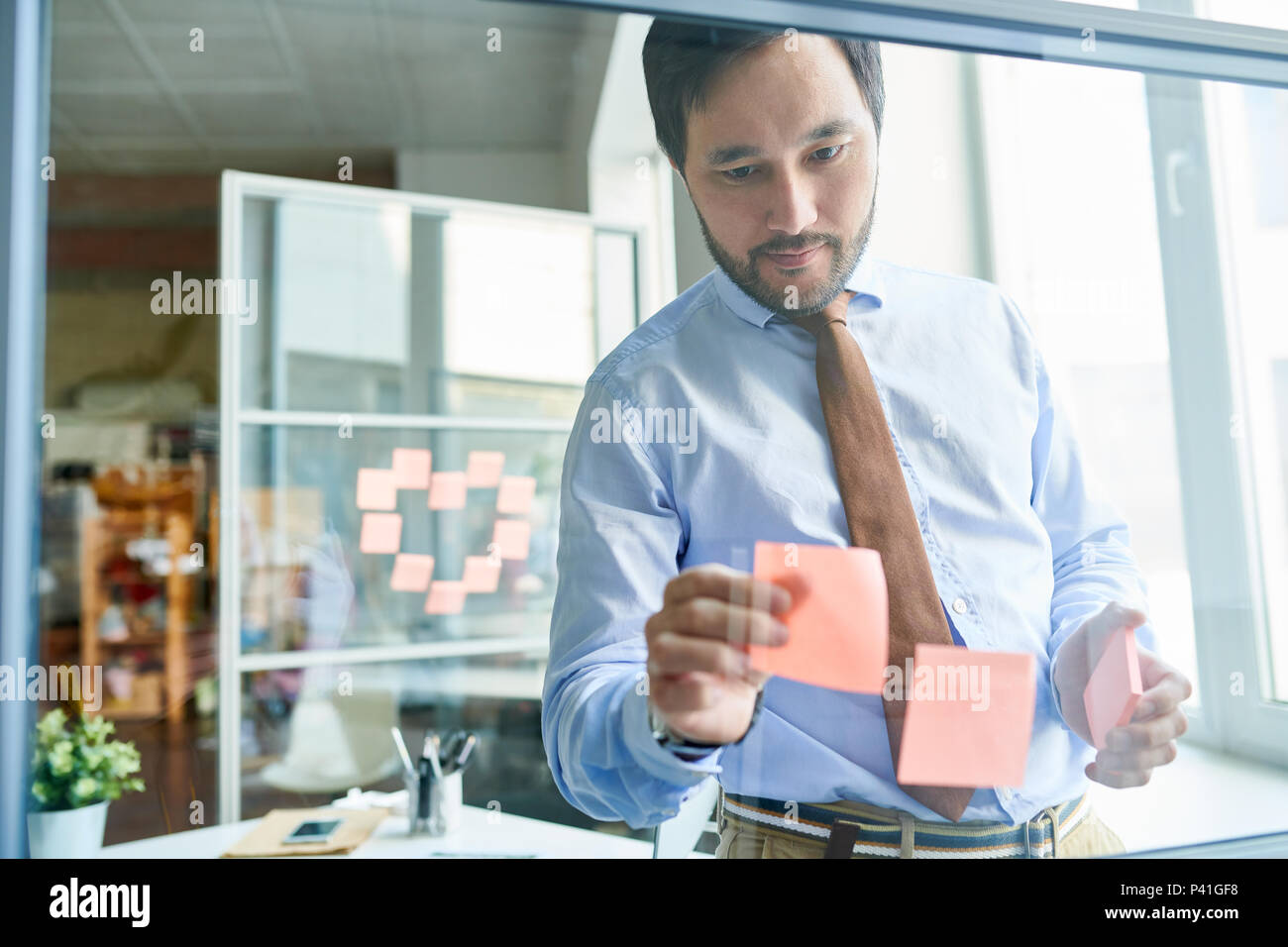 Creative man arranging stickers on board Stock Photo - Alamy