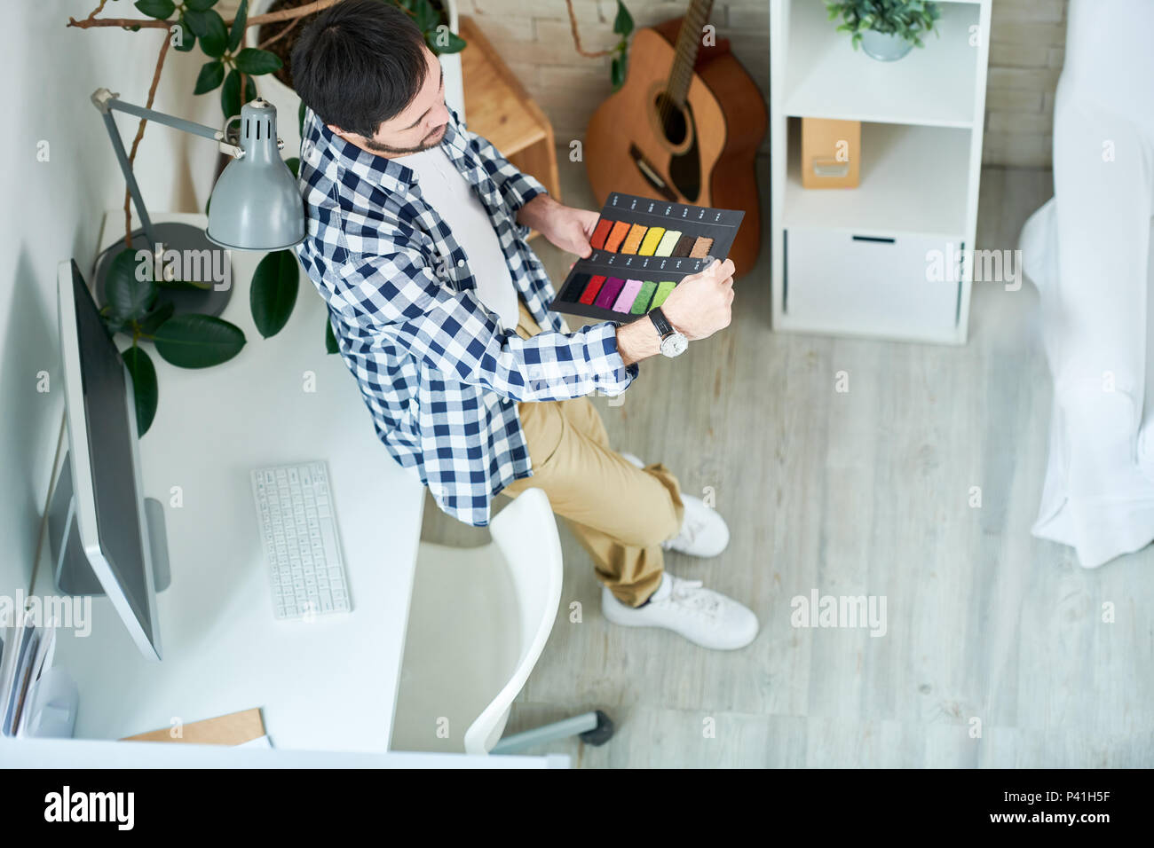 Thinking man working with color choice in office Stock Photo - Alamy