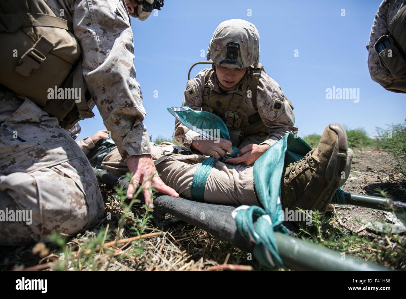 Hospital Corpsman 3rd Class Steven P. Kelly ties a role-player’s legs ...