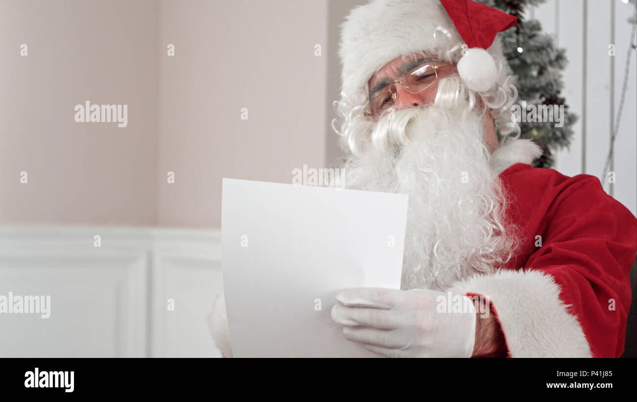 Santa Claus finishing writing and checking his letter to a kid Stock ...
