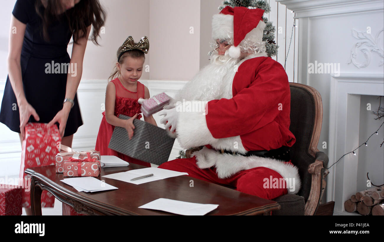 Busy Santa answering chidlren's letters while Santa's little helpers ...