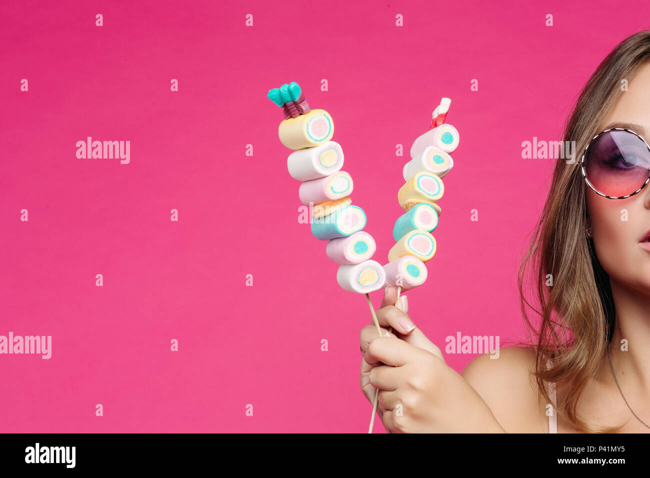 Seductive girl in pink sunglasses posing with marshmallow candy Stock ...