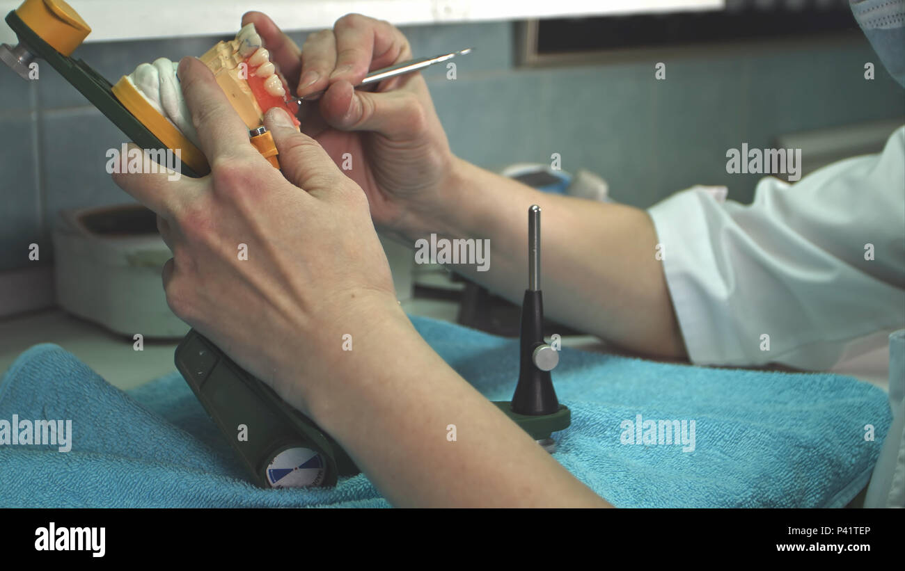 Dental technician removes excess wax from denture with a scalpel Stock ...