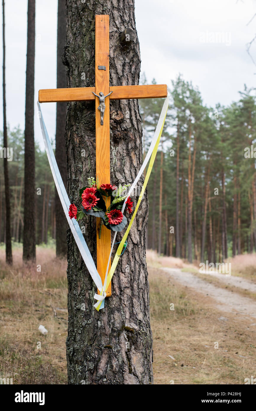 Holy cross at a dirt road in the forest. A forested sandy path leading ...