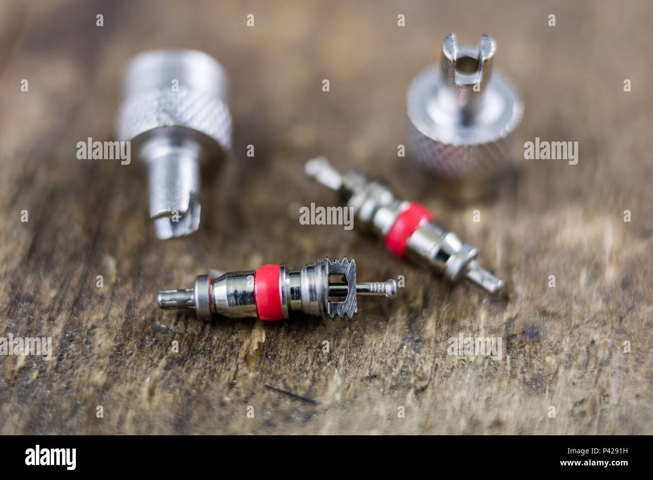 Inner tube valve on a wooden workshop table. Accessories for vulcanizer ...