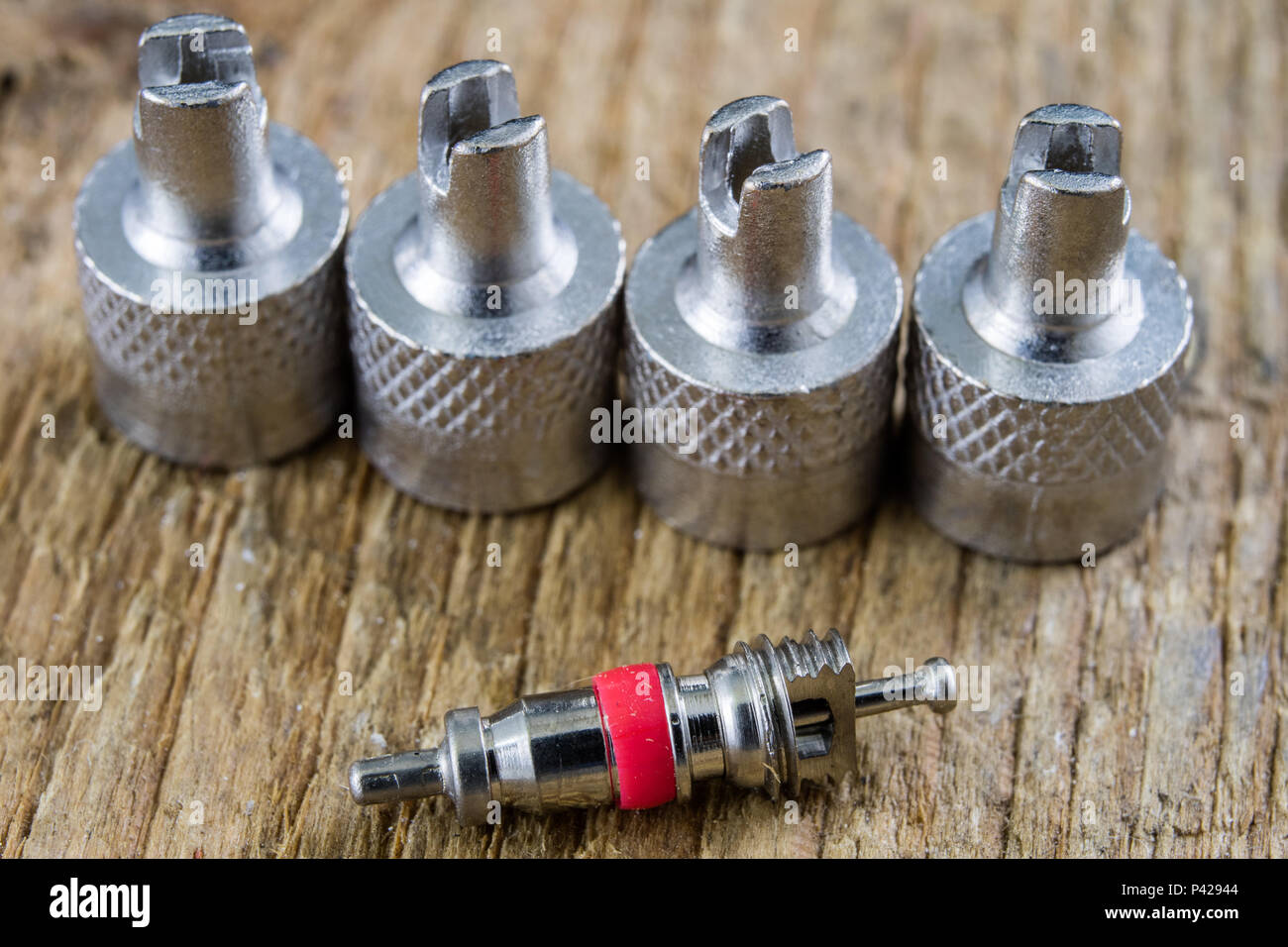Inner tube valve on a wooden workshop table. Accessories for vulcanizer ...