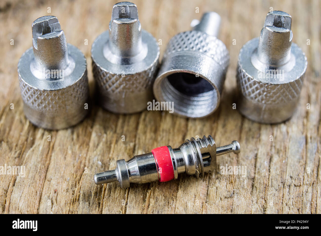 Inner tube valve on a wooden workshop table. Accessories for vulcanizer ...
