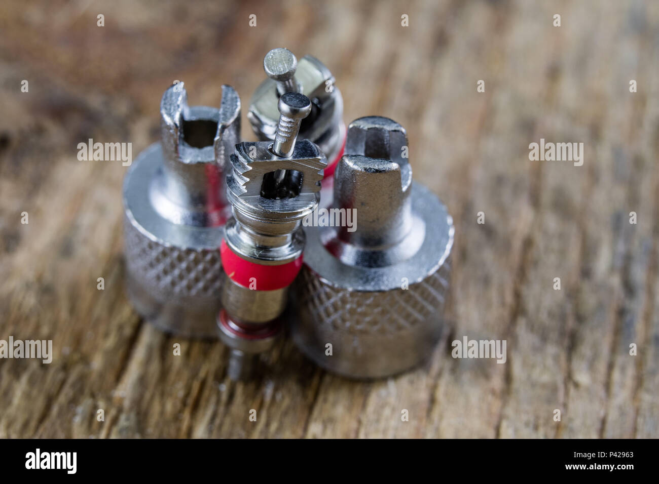 Inner tube valve on a wooden workshop table. Accessories for vulcanizer ...