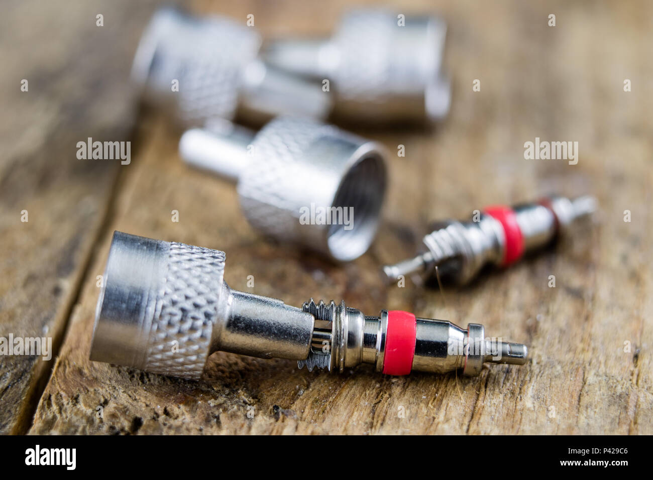 Inner tube valve on a wooden workshop table. Accessories for vulcanizer ...