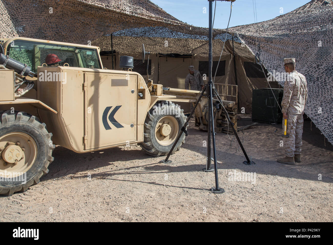 A Rough Terrain Telescopic forklift moves a generator beside the combat ...