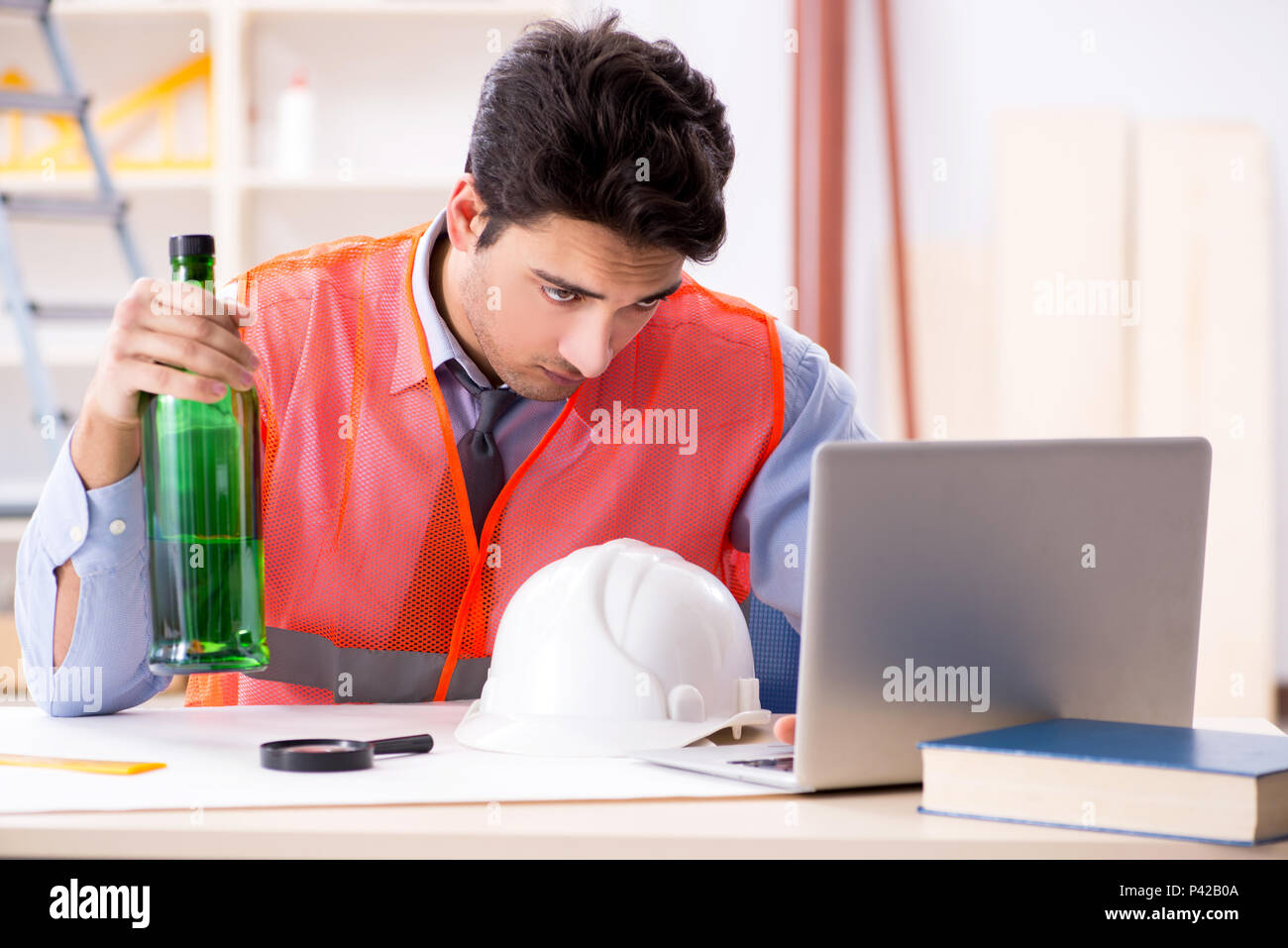Drunk engineer working in the workshop Stock Photo - Alamy