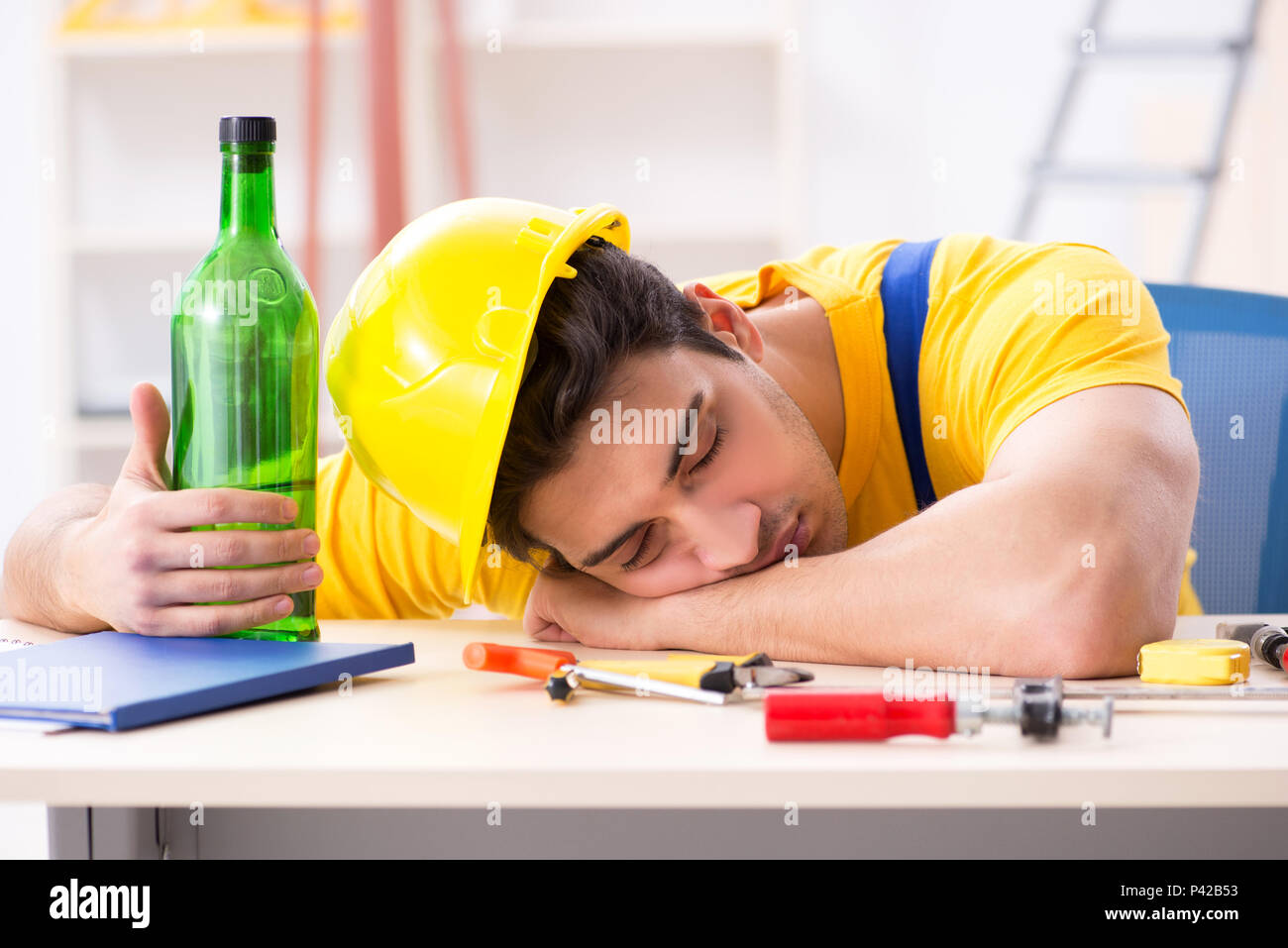 Drunk engineer working in the workshop Stock Photo - Alamy