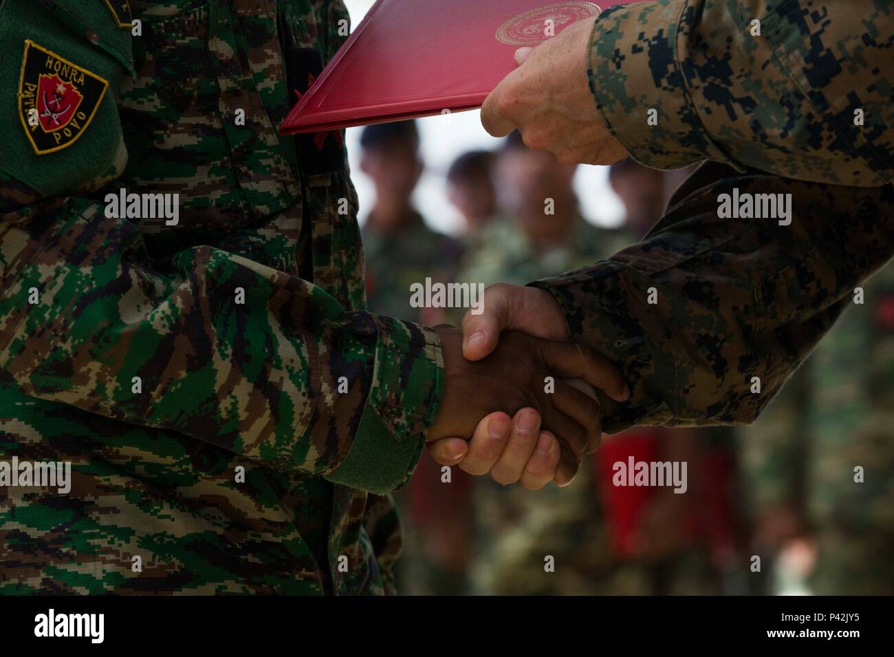 U.S. Marine Maj. Todd A. Peterson with Task Force Koa Moana, awards the ...
