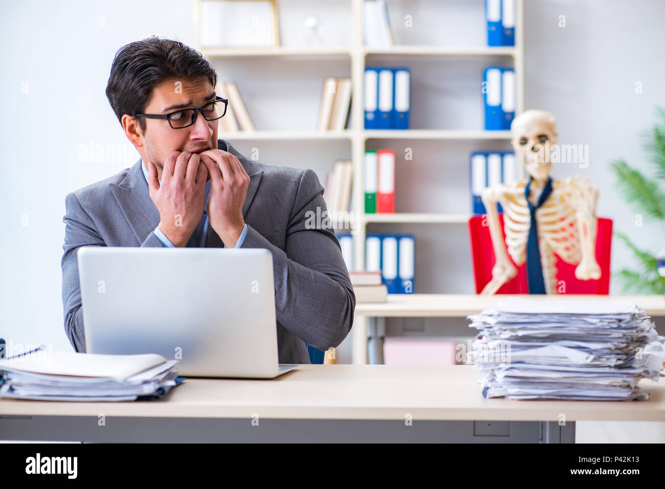 Businessman working with skeleton in office Stock Photo - Alamy