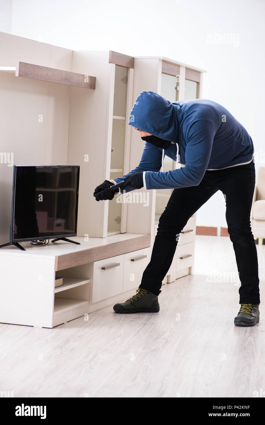 Man burglar stealing tv set from house Stock Photo - Alamy
