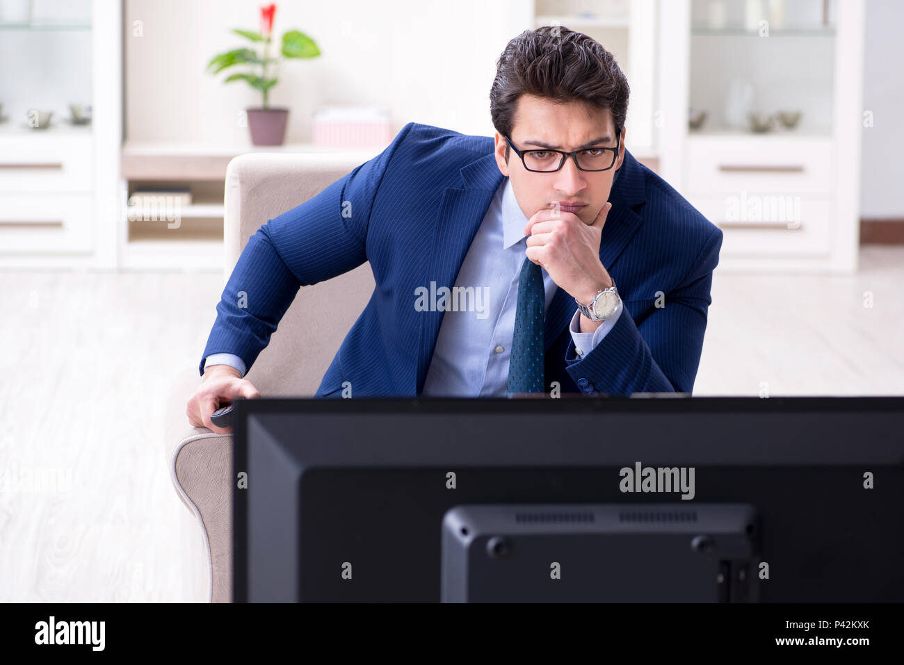 Businessman watching tv in the office Stock Photo - Alamy