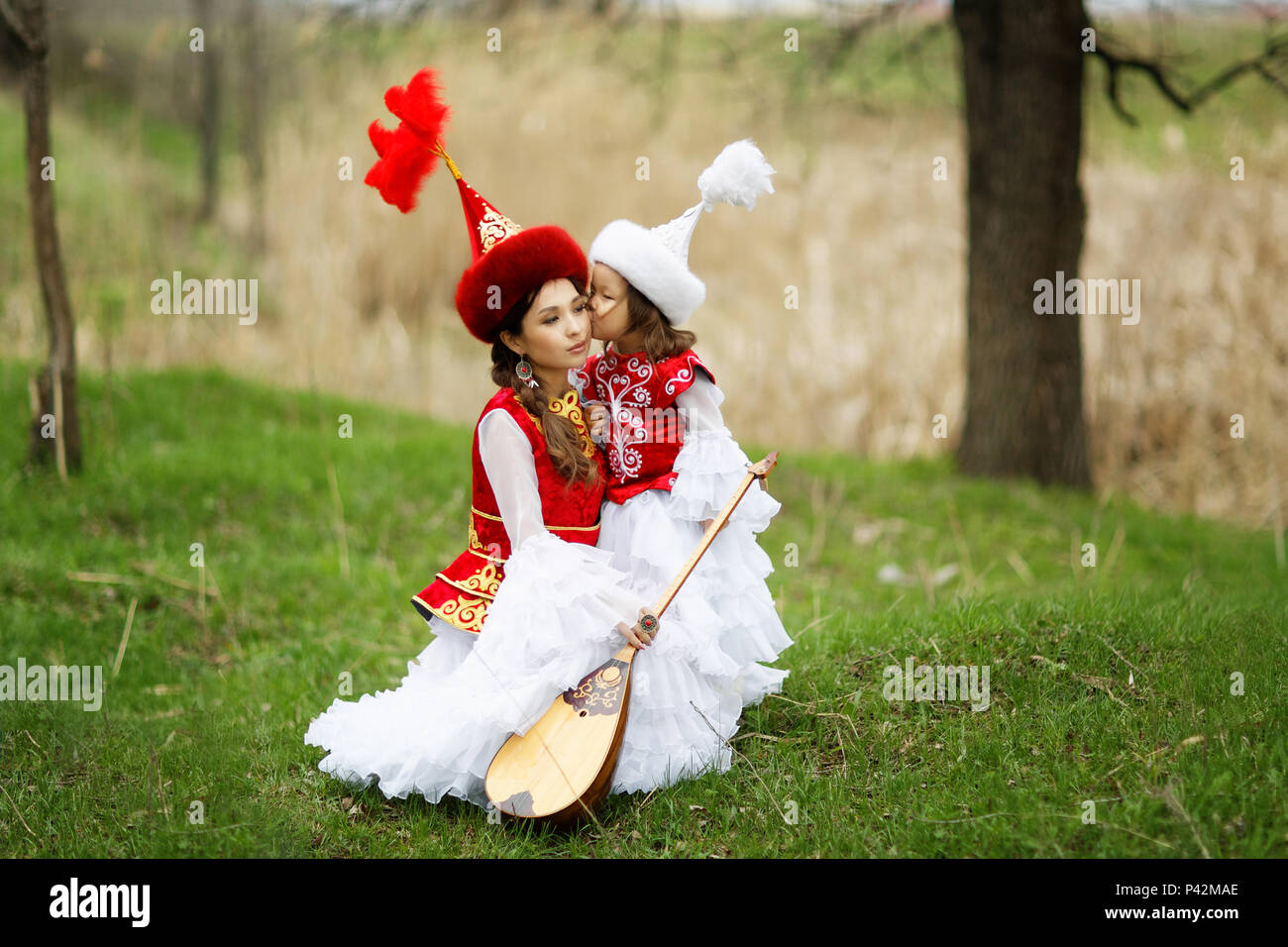 Kazakh people in national costumes. Woman and daughter in the park ...