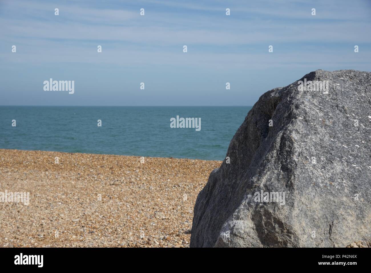 Beach: granite boulders on a pebble beach overlooking the English ...