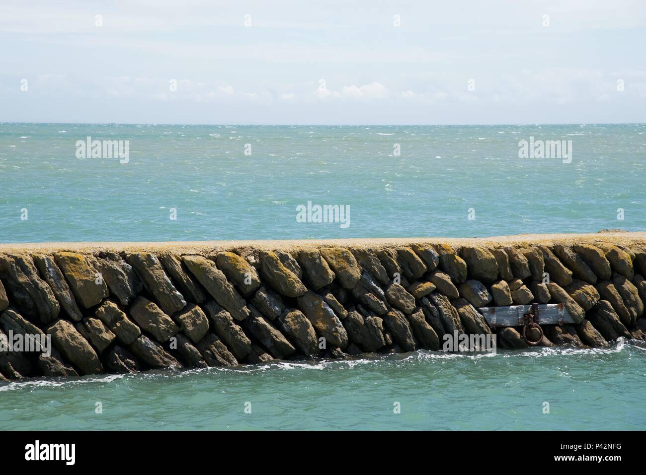 Sea wall: a sea wall constructed from flat rock formations set in an ...