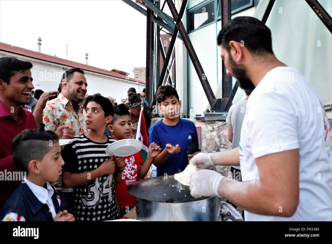Kids getting food during the celebration. Greek citizens and refugees ...