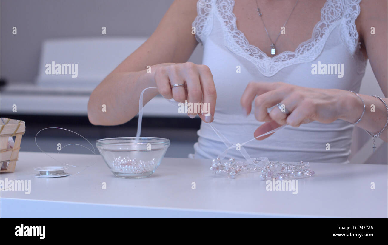 Young woman assembling her handmade jewelry Stock Photo - Alamy