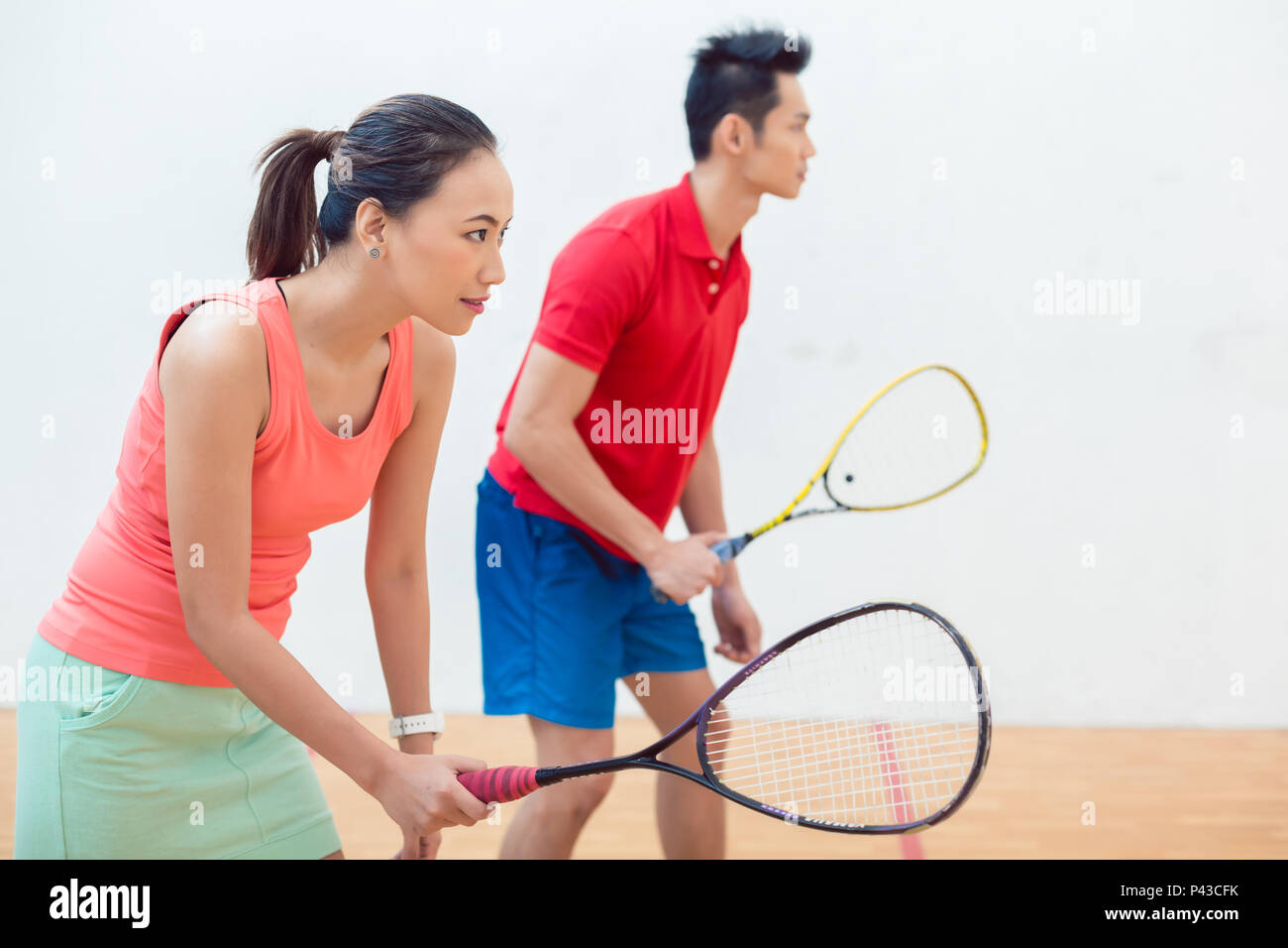 Competitive Chinese woman holding the racquet during a squash game ...