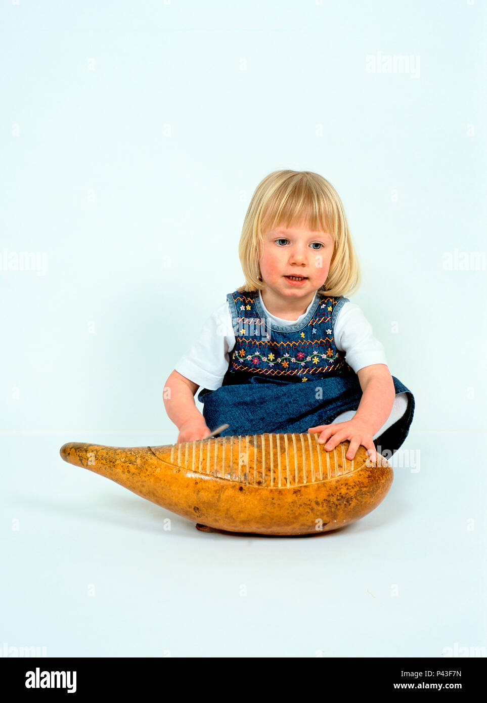 Child playing a Guiro Stock Photo - Alamy