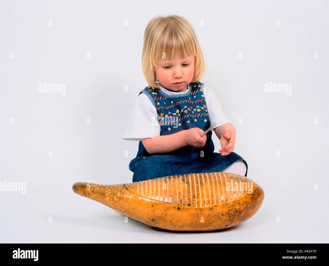 Child playing a Guiro Stock Photo - Alamy