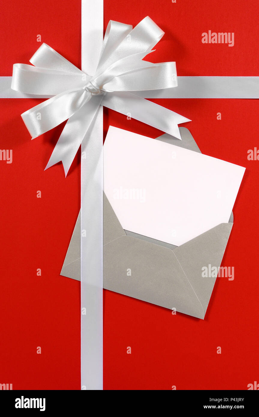 Christmas card with gift ribbon and bow in white satin on red paper ...