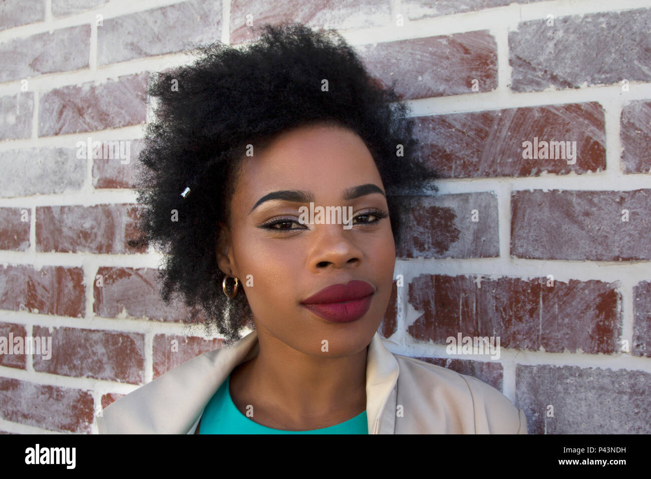 Female against brick wall hi-res stock photography and images - Alamy