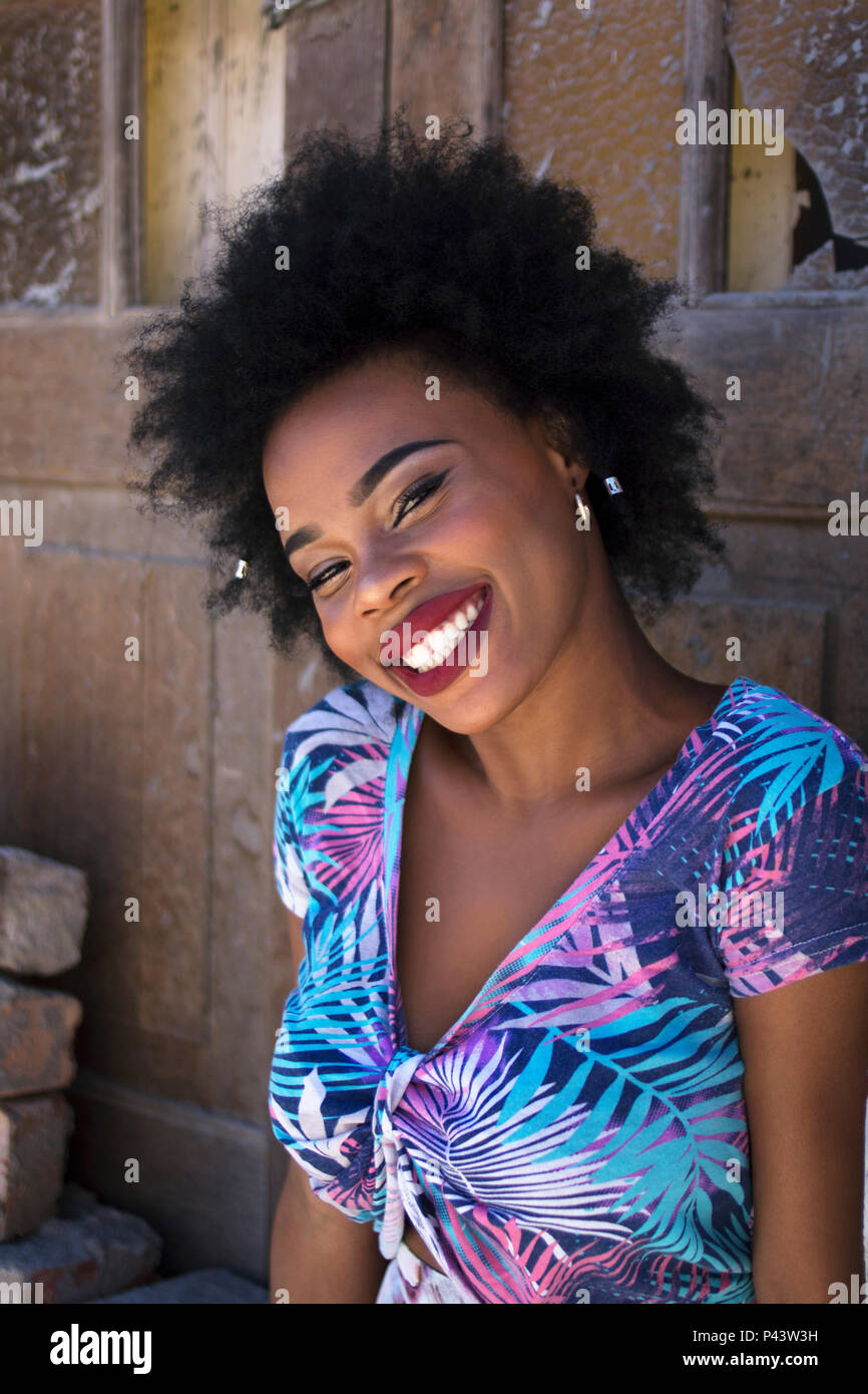 An African model sits on an old stone wall and wooden door Stock Photo ...