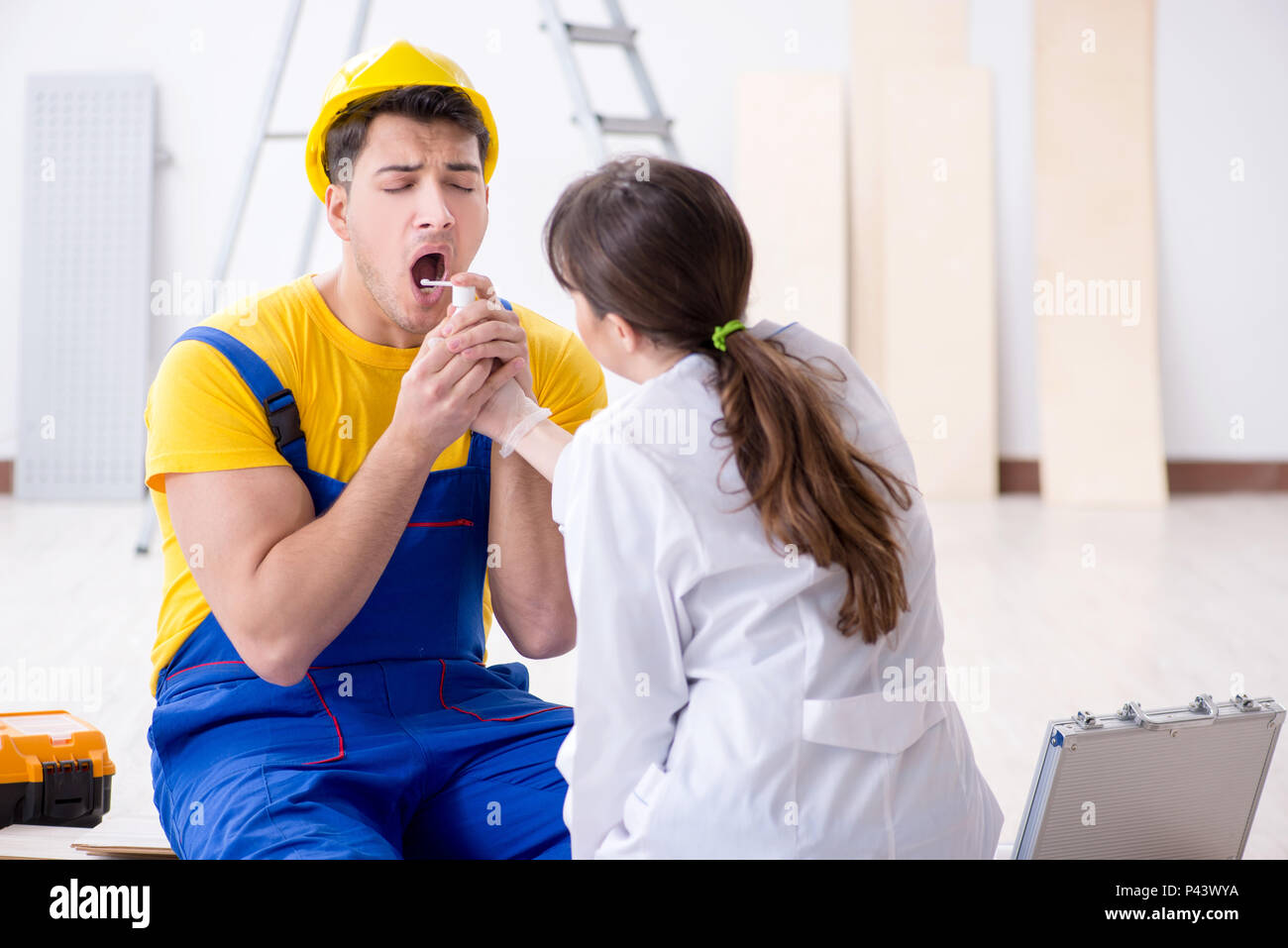 Doctor helping injured worker at construction site Stock Photo - Alamy