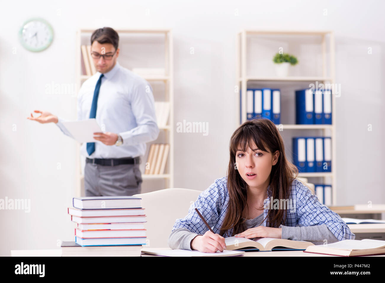 Male lecturer giving lecture to female student Stock Photo - Alamy