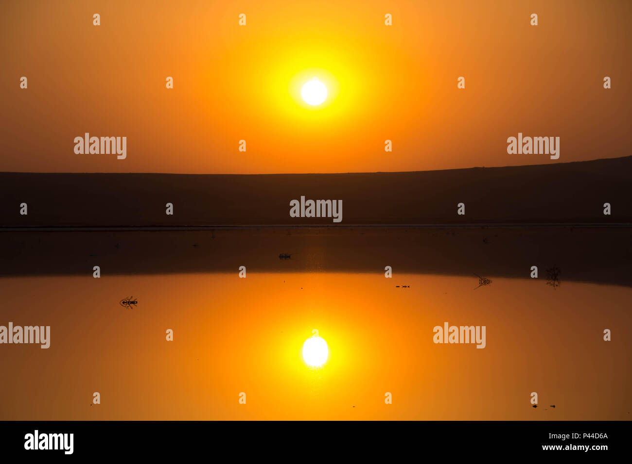 Sunrise over salt lake and reflection of sunlight in water Stock Photo ...