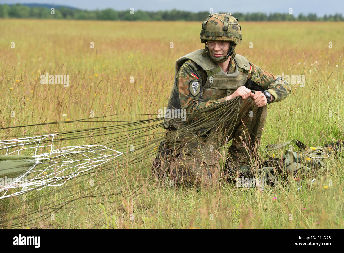 A German Army paratrooper packs his parachute after jumping into Bunker ...