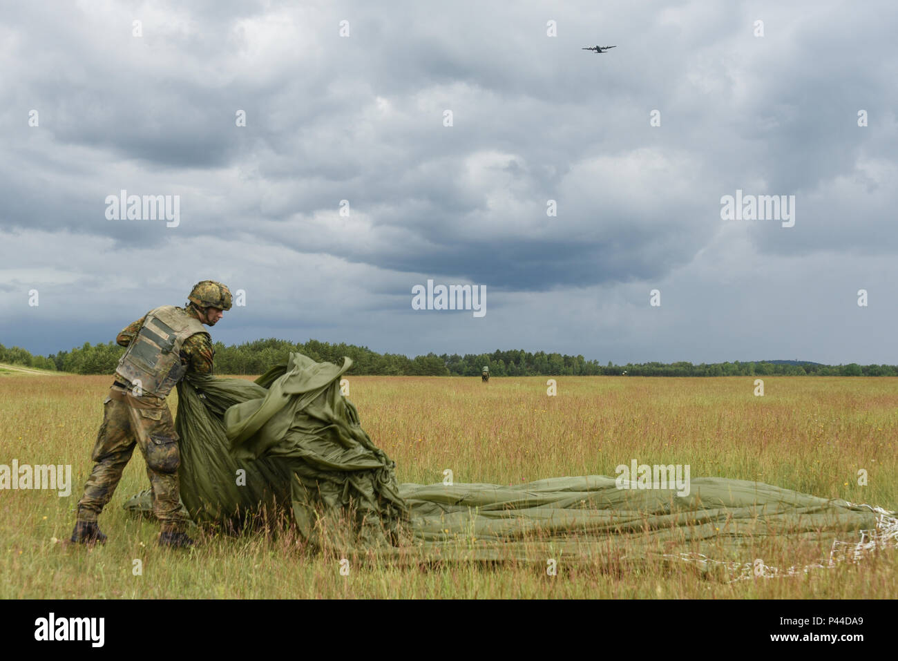 A German Army paratrooper packs his parachute after jumping into Bunker ...