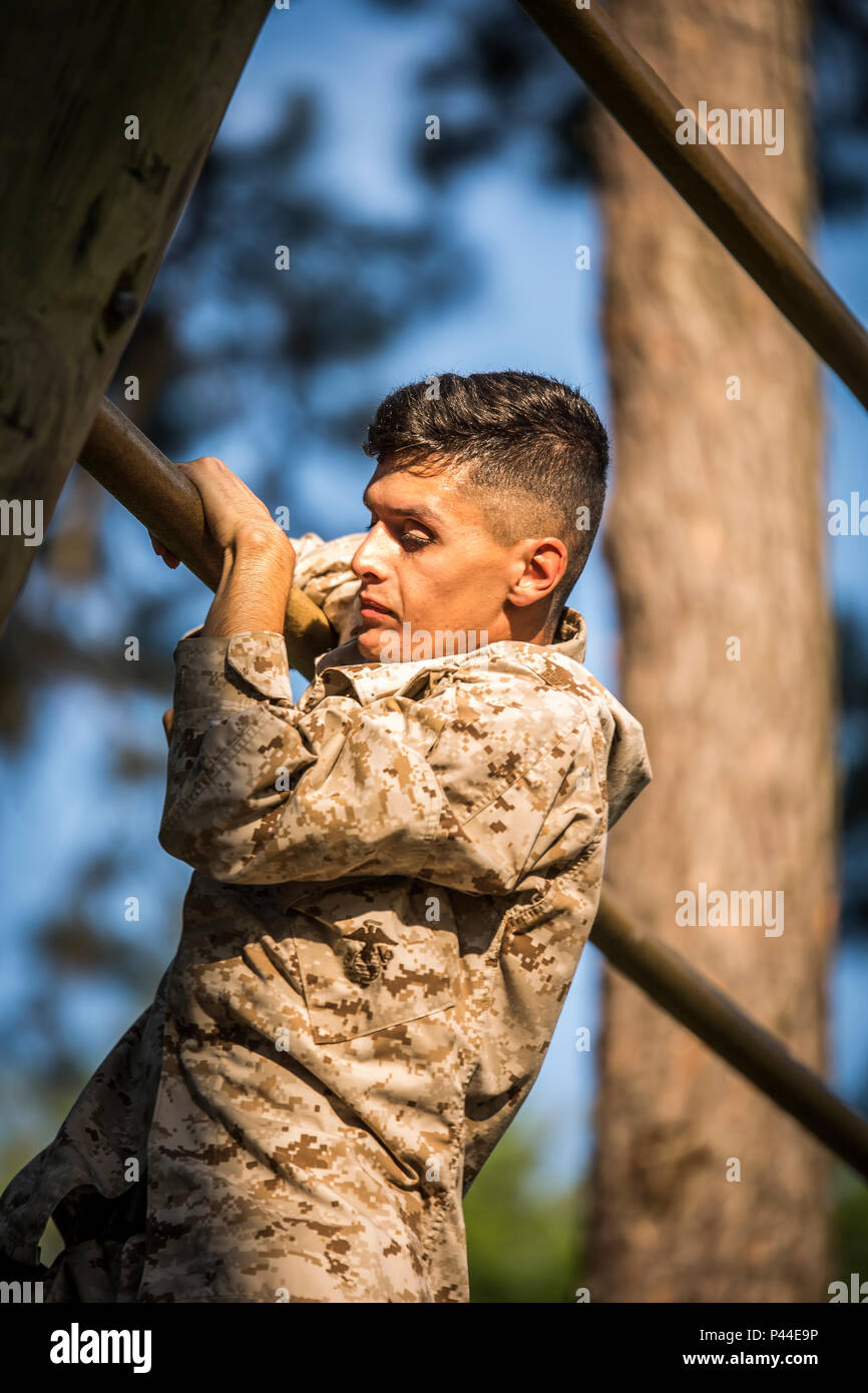 A Marine climbs an obstacle at the confidence course on Marine Corps ...