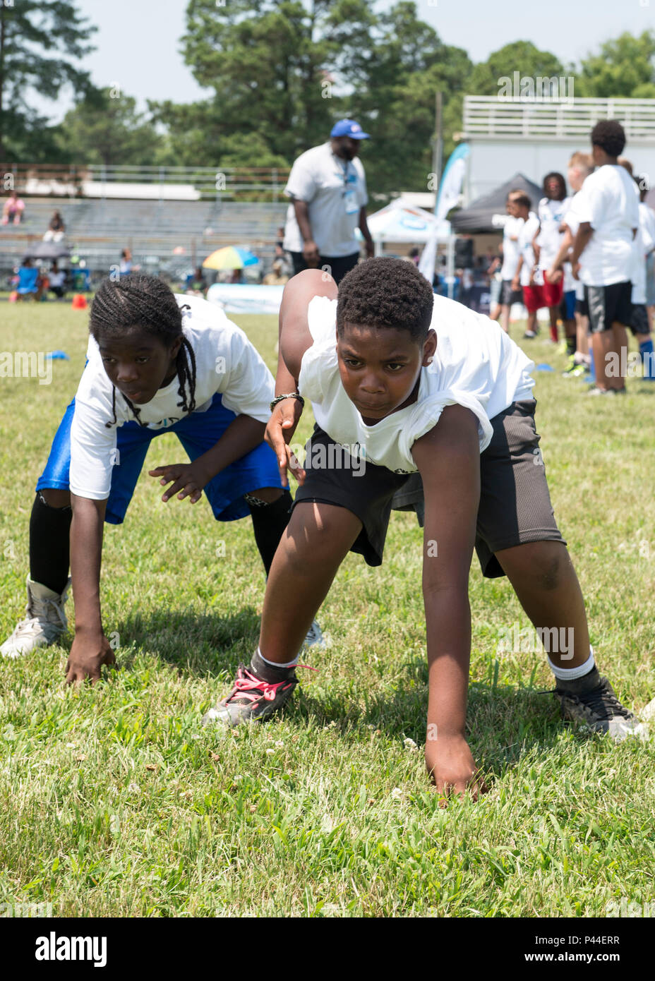 Two participants practice the three-point stance during a football Pro ...