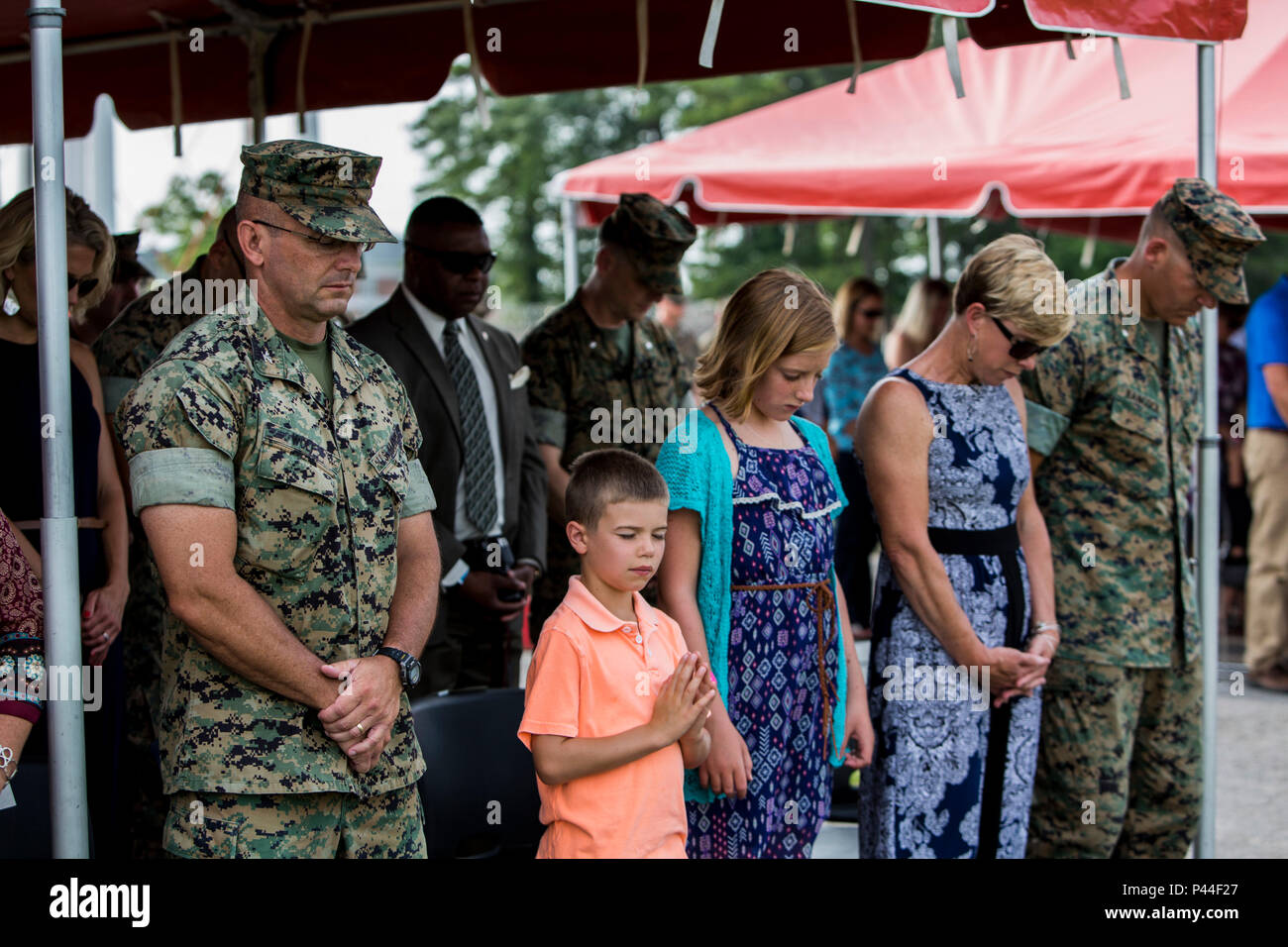 U.S. Marines, family, and friends bow their heads during the invocation ...