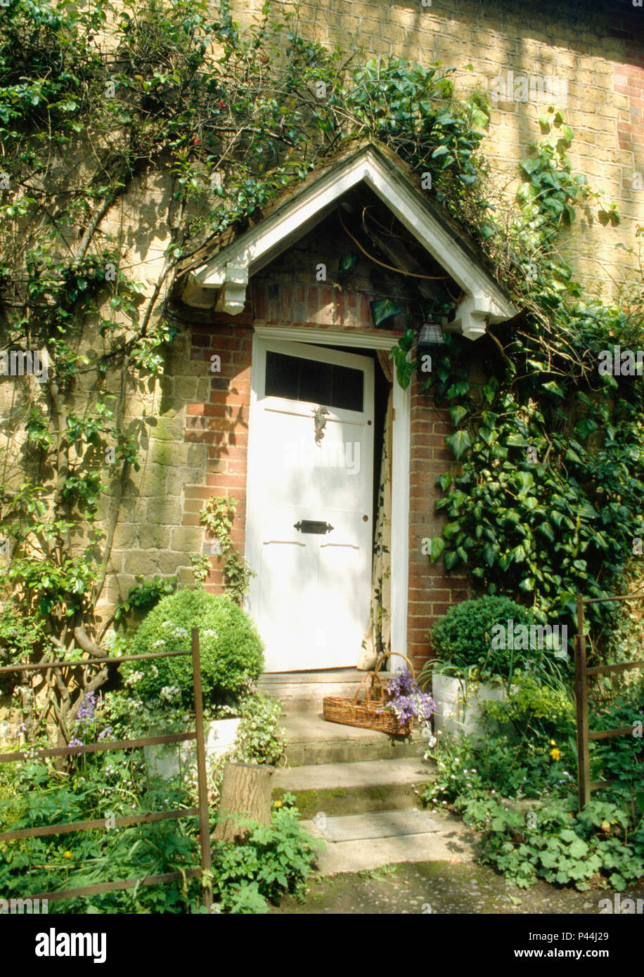 Exterior of country cottage with a small apex porch on white front door ...