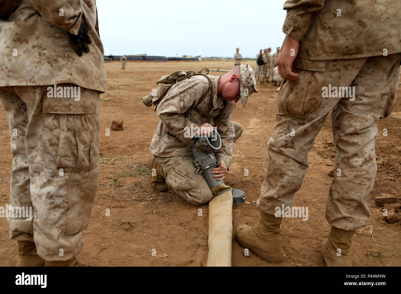 U.S. Marine Lance Cpl. Josh Allen affixes a connecting elbow to a four ...