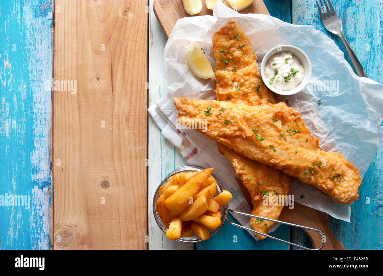 Traditional British fried fish in batter with chips in a basket Stock ...