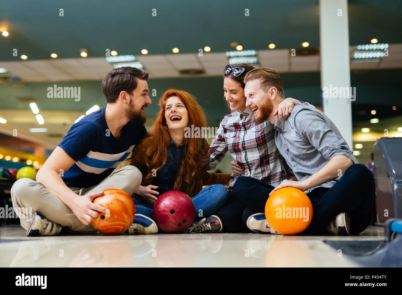 Cheerful friends bowling together Stock Photo - Alamy