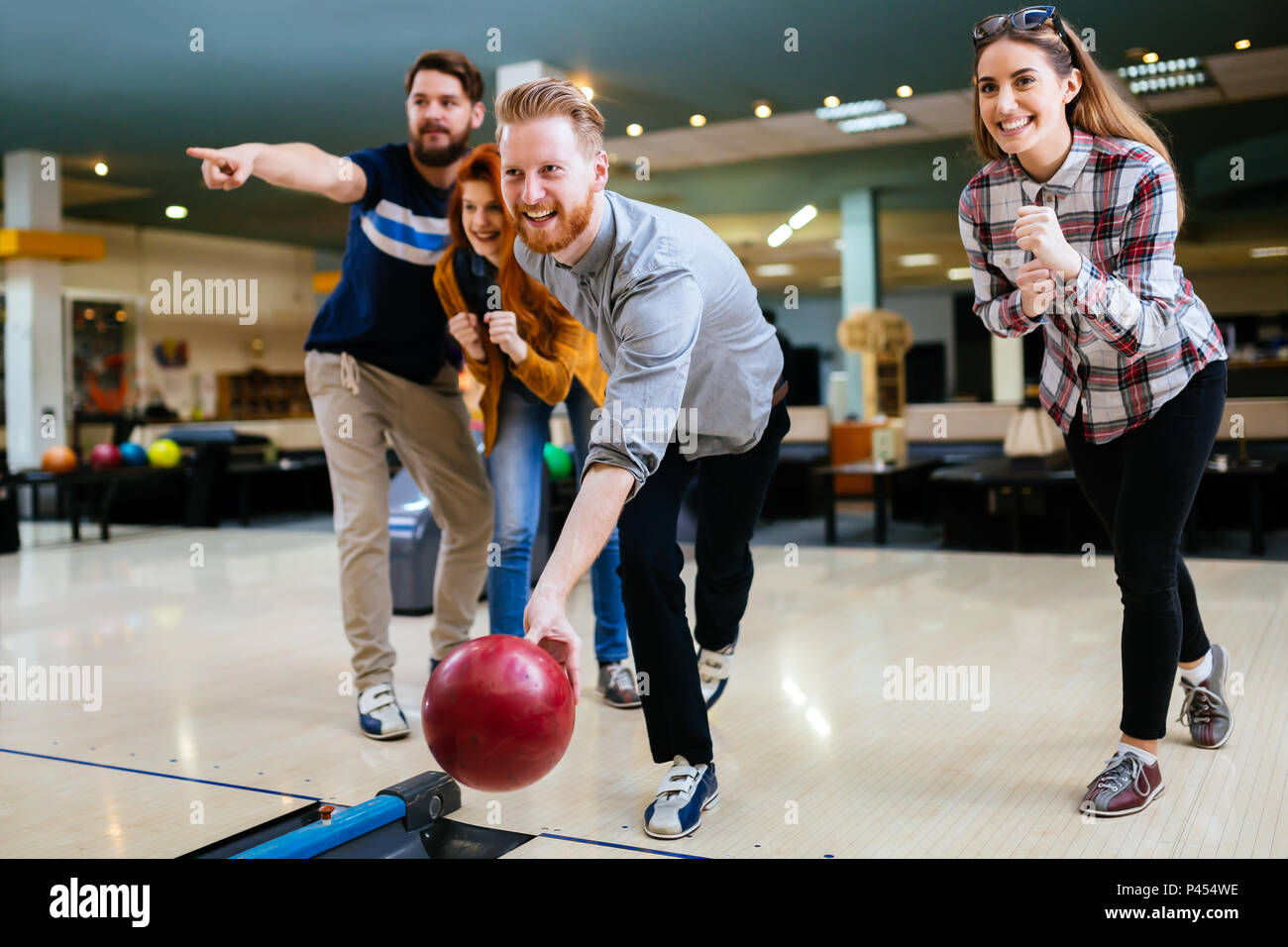 Friends having fun while bowling Stock Photo - Alamy