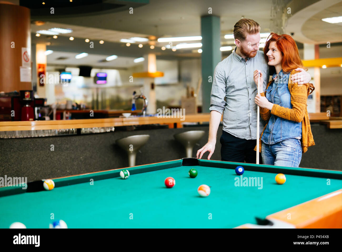 Beautiful couple playing billiards Stock Photo - Alamy