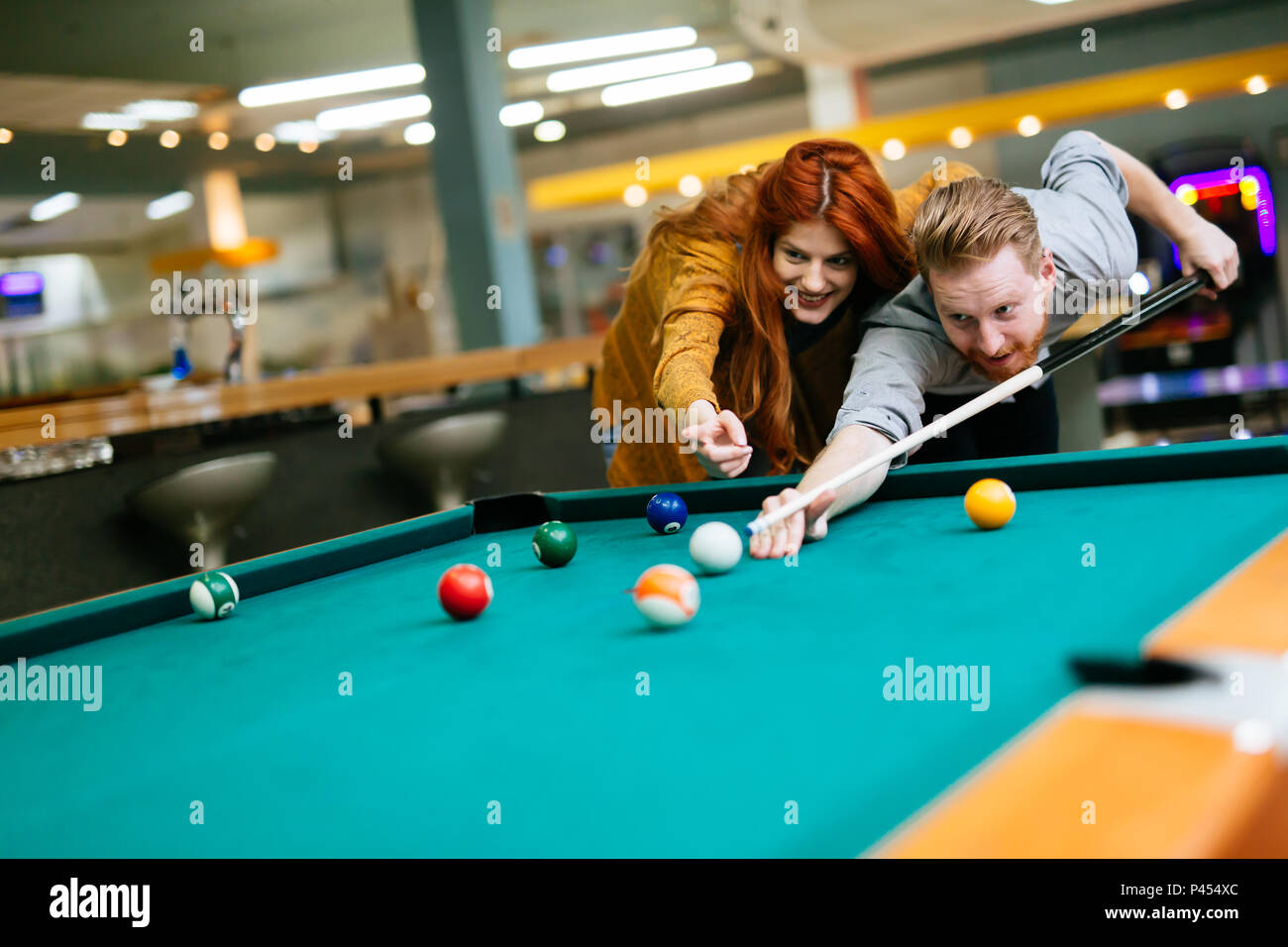 Beautiful couple playing billiards Stock Photo - Alamy