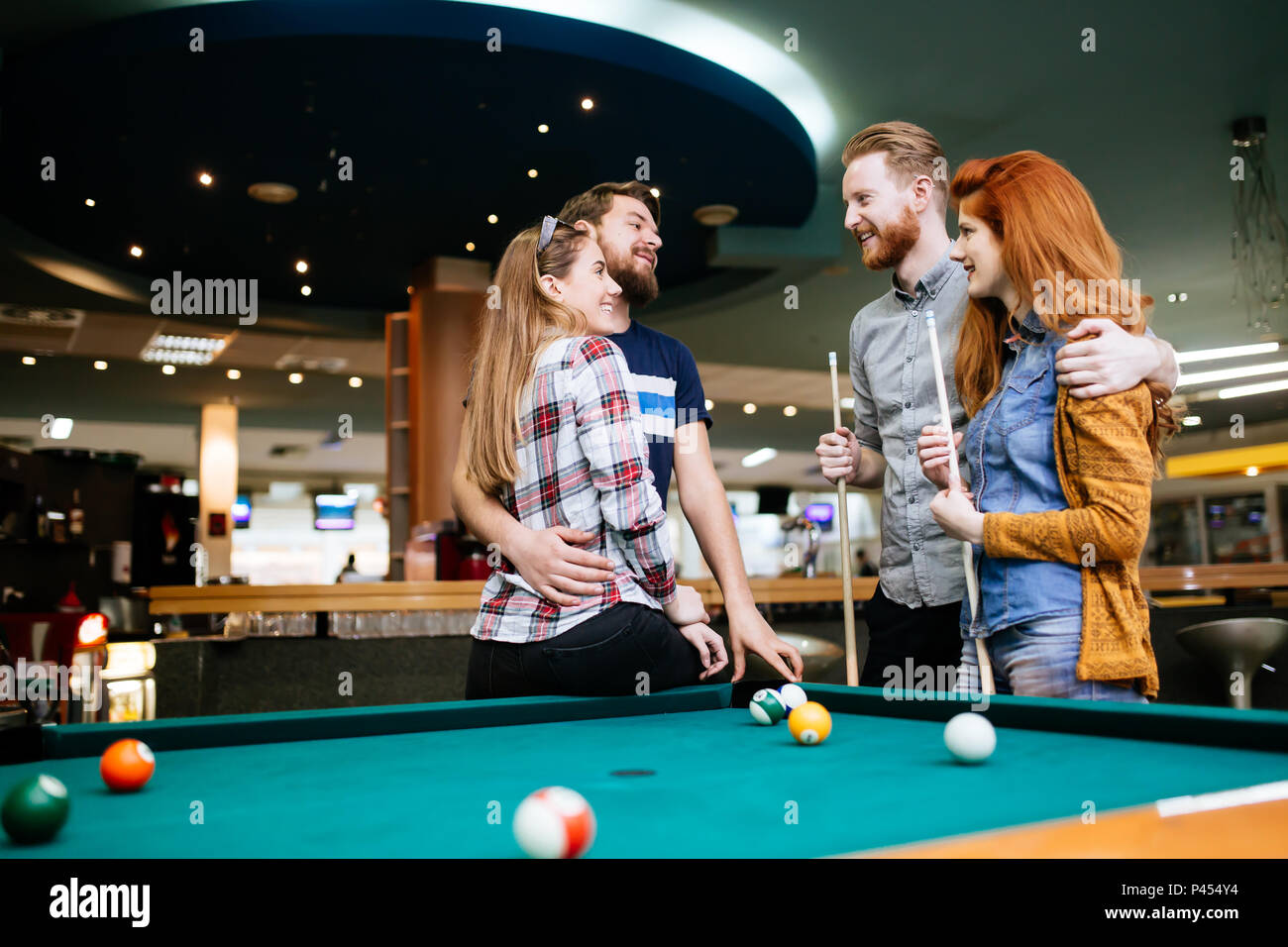 Happy friends enjoying playing pool Stock Photo - Alamy