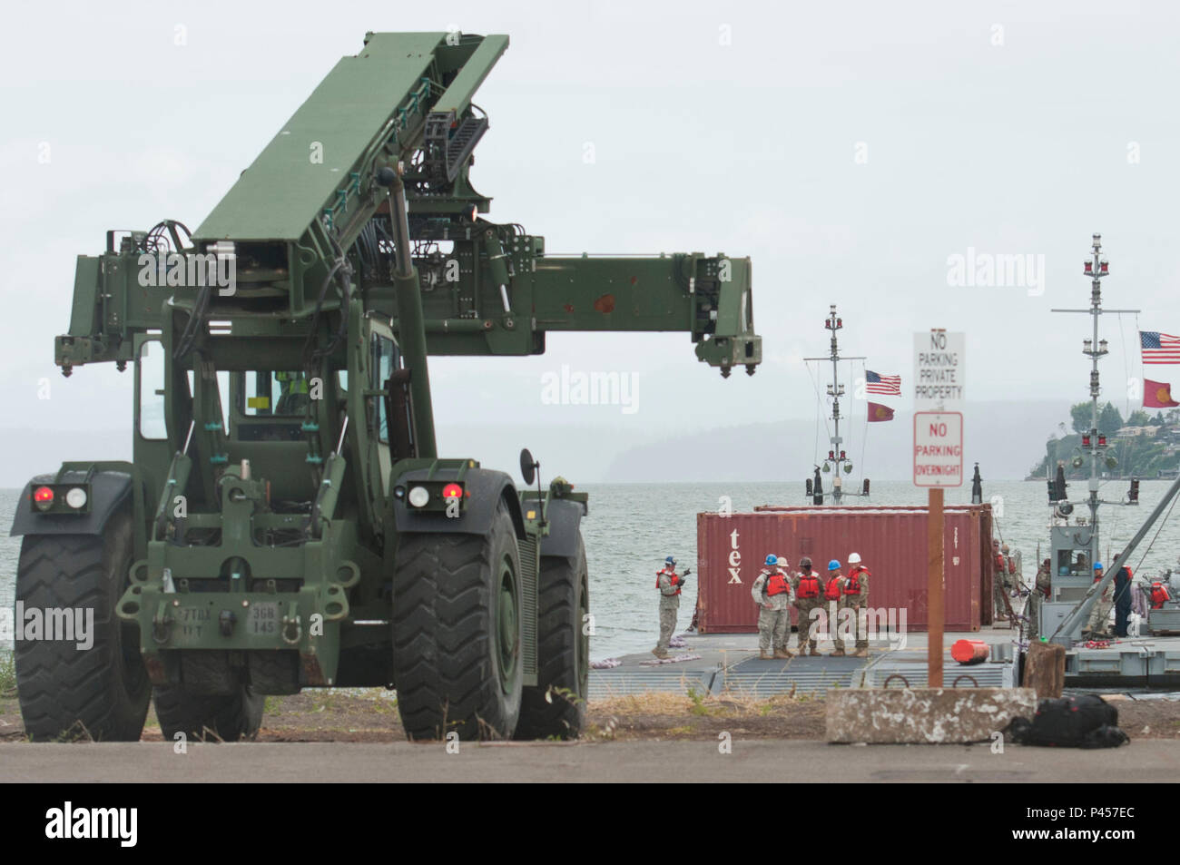 A Rough Terrain Container Handler waits to download containers from a ...
