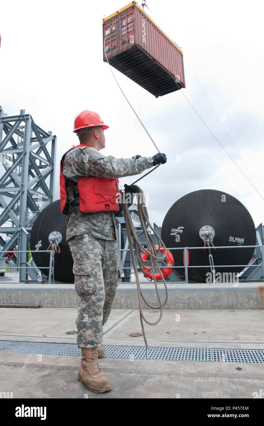 A Soldier with the 11th Transportation Battalion guides a shipping ...