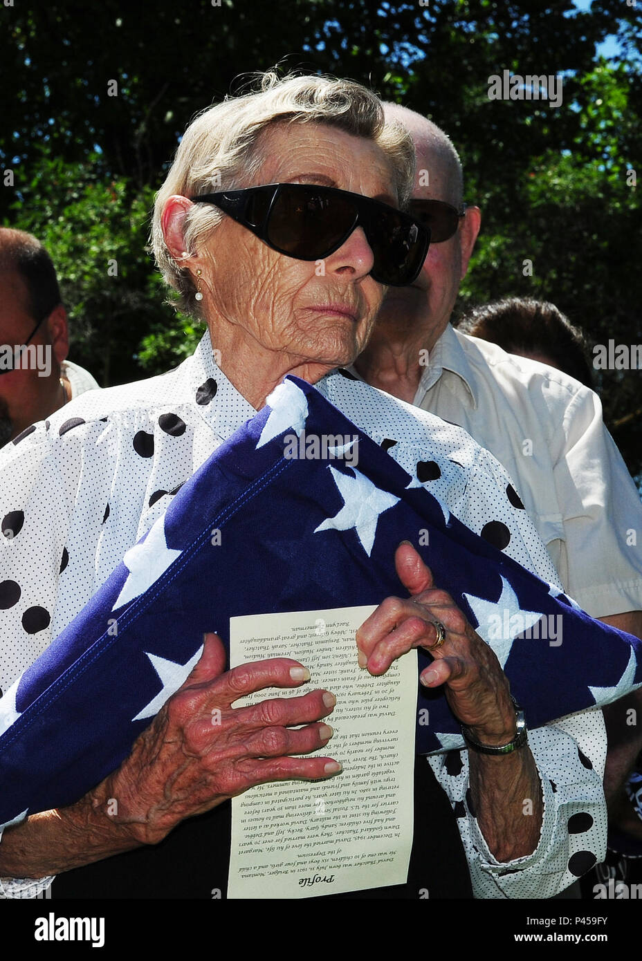 Dawn Thatcher, wife of Staff Sgt. David J. Thatcher, receives the flag ...